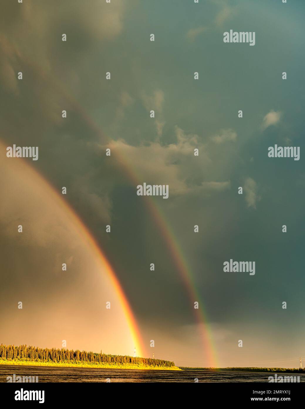 A panorama of a double rainbow against a backdrop of bright clouds ...