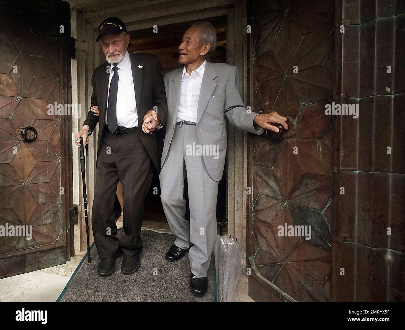 Tatsuya Yasue, right, and WWII veteran Marvin Strombo walk together out ...