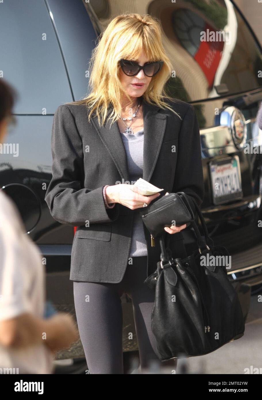 Melanie Griffith looks upscale and chic in a black jacket, grey top and ...
