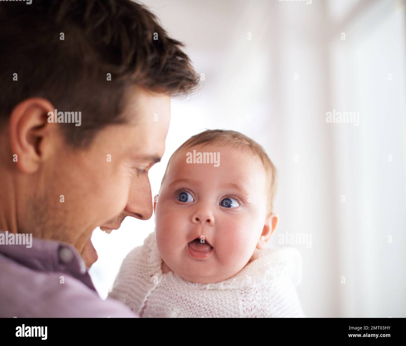 What big eyes you have. a young father looking at his adorable baby ...