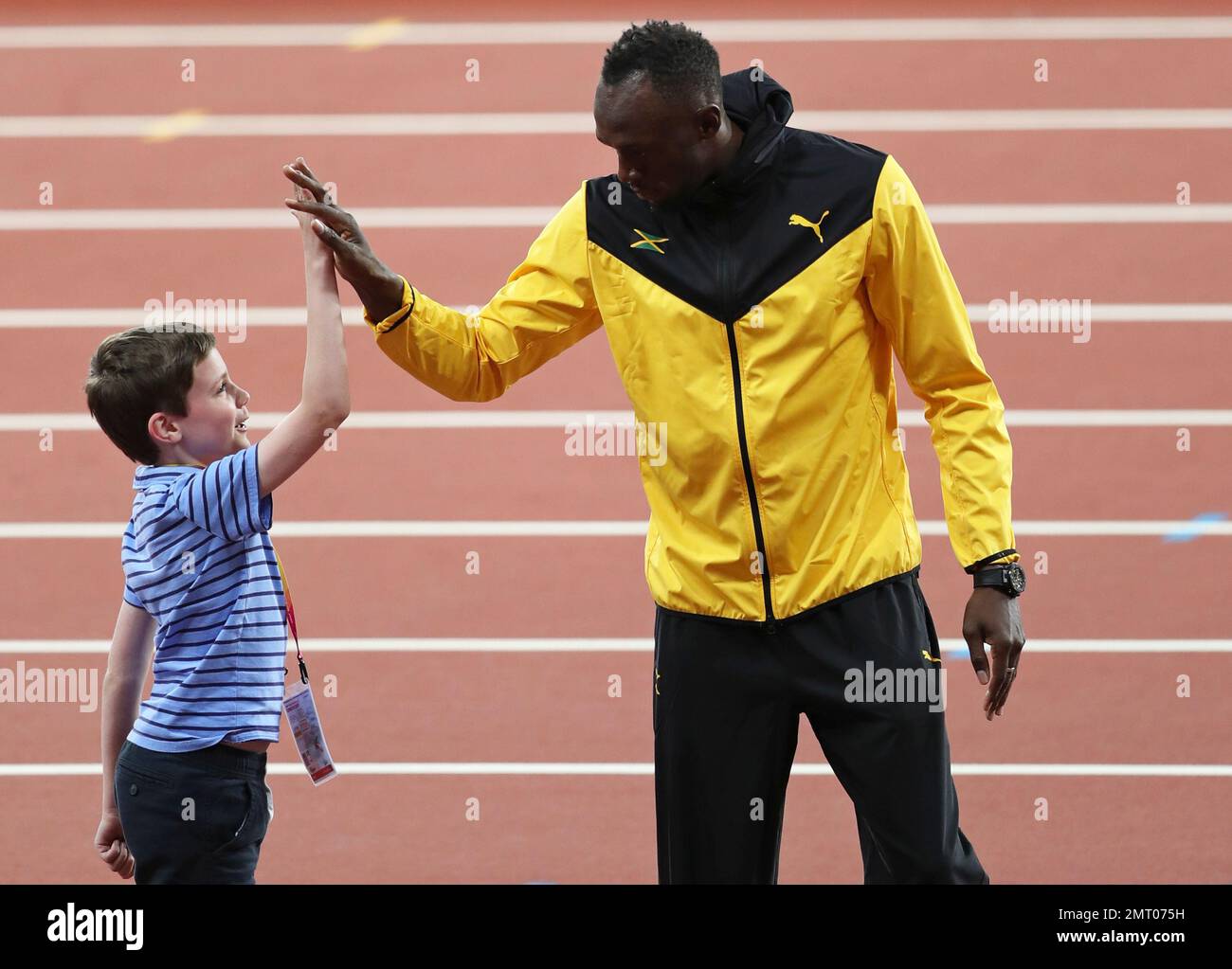 Jamaica's Usain Bolt greets a young boy during his lap of honor at the ...