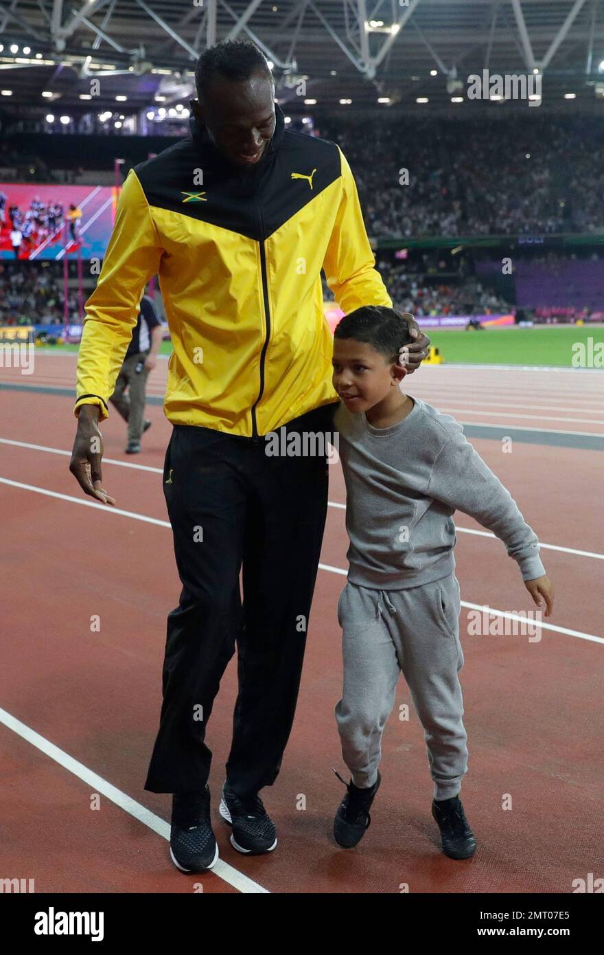 Jamaica's Usain Bolt is hugged by a child during his lap of honor at ...