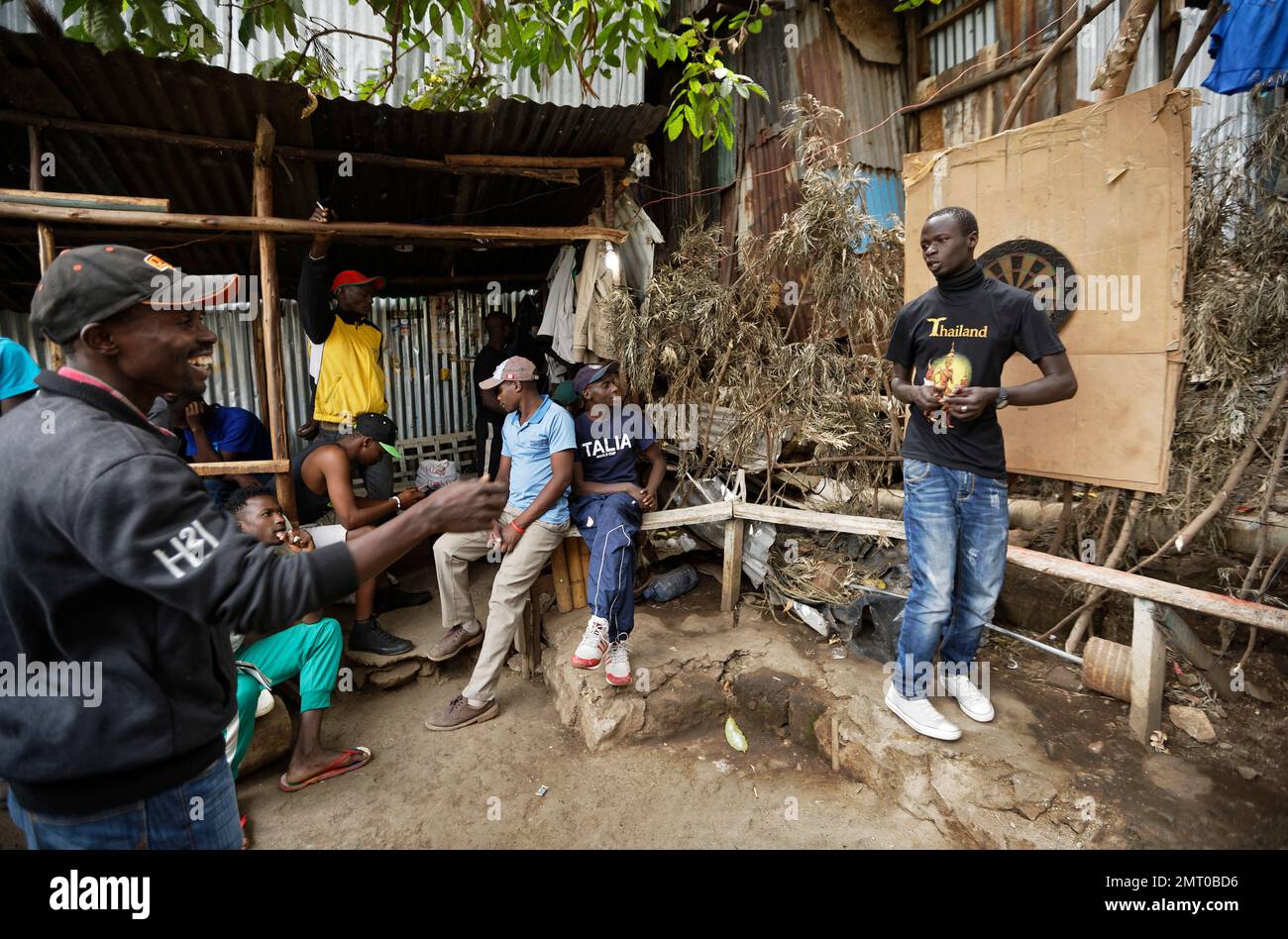 Kenyan youth play darts outside the shack they use as a youth center ...