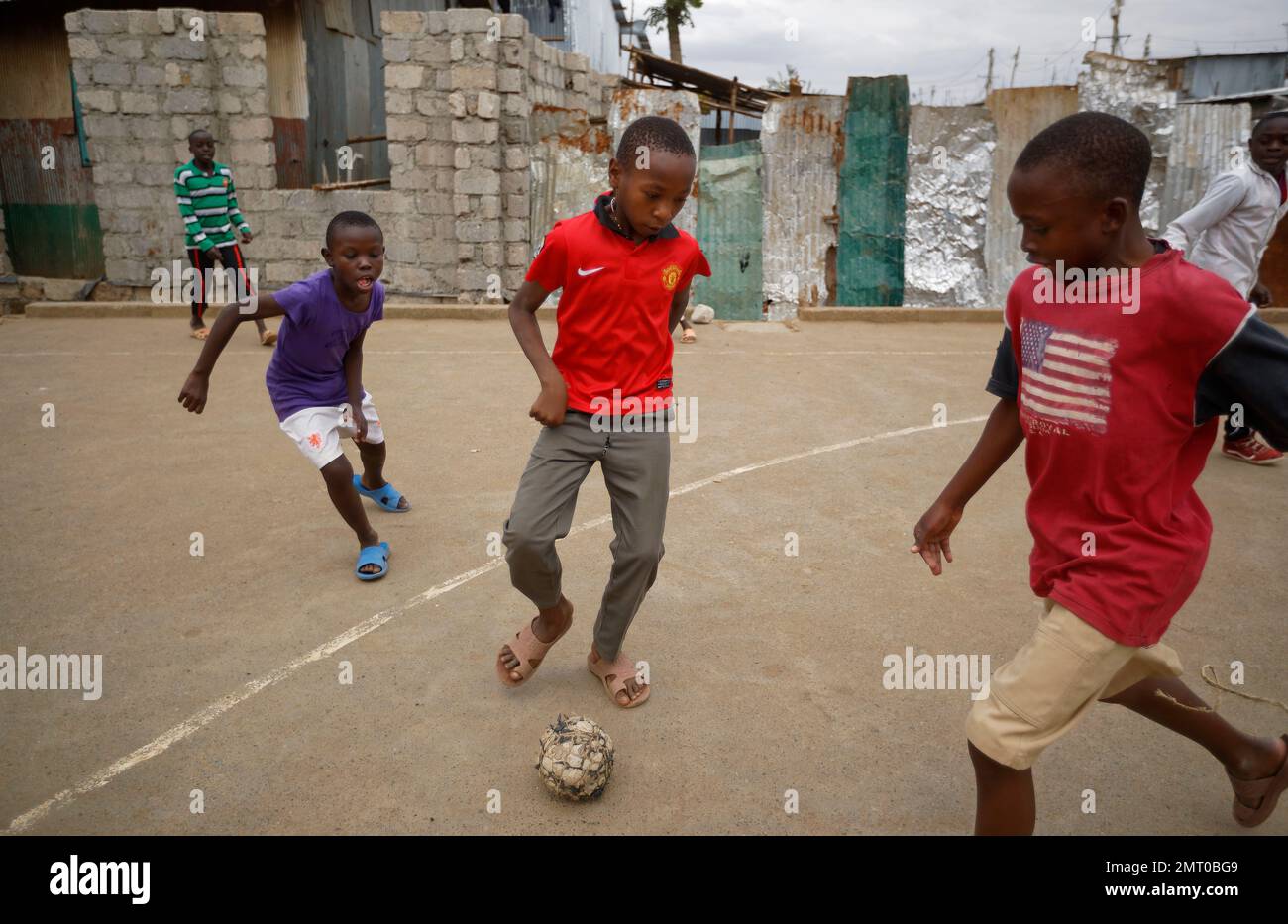 Young Kenyan children play soccer inside the Mathare area of Nairobi ...