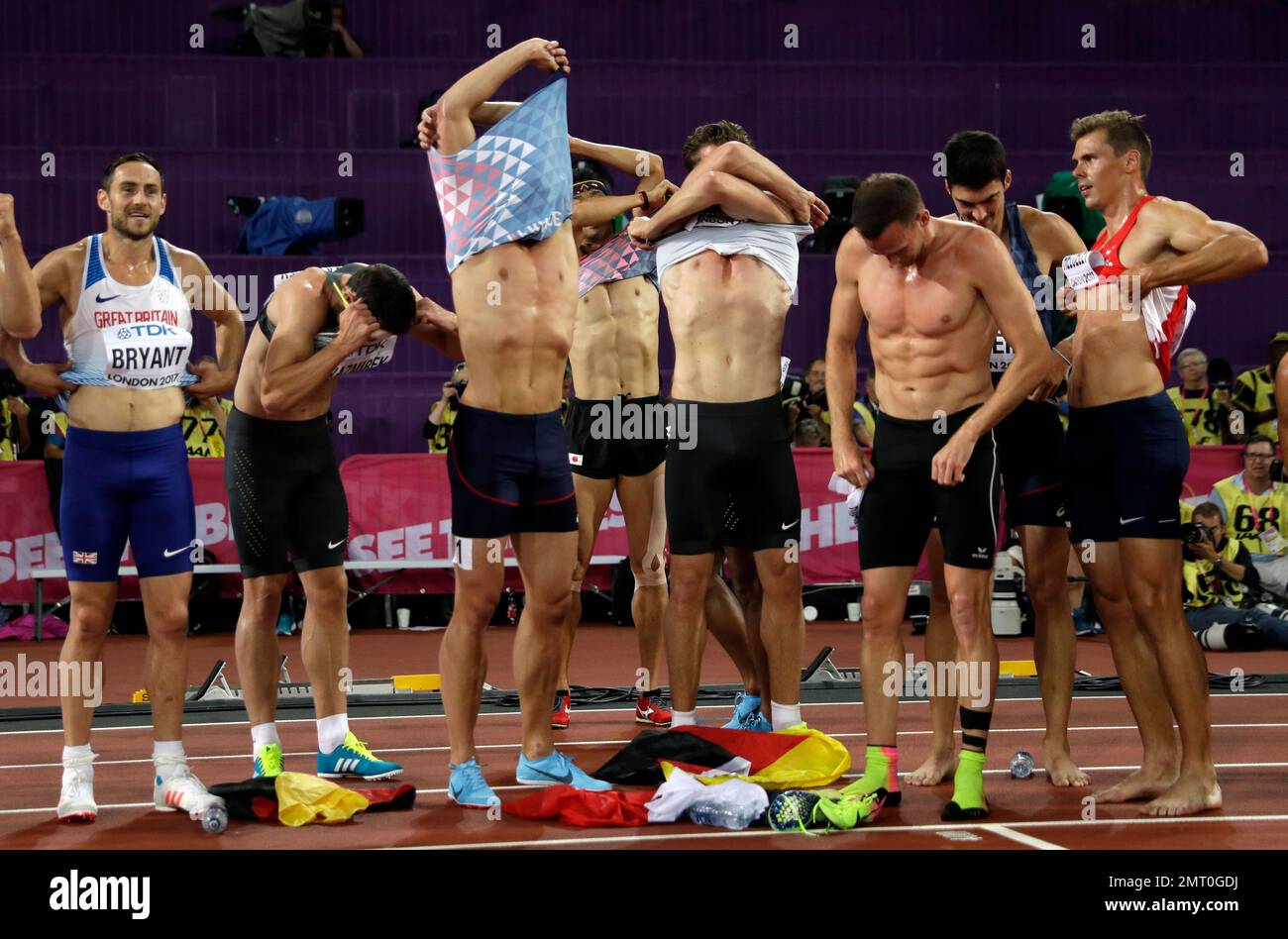 The athletes take off their shirts to pose for a photo after the ...