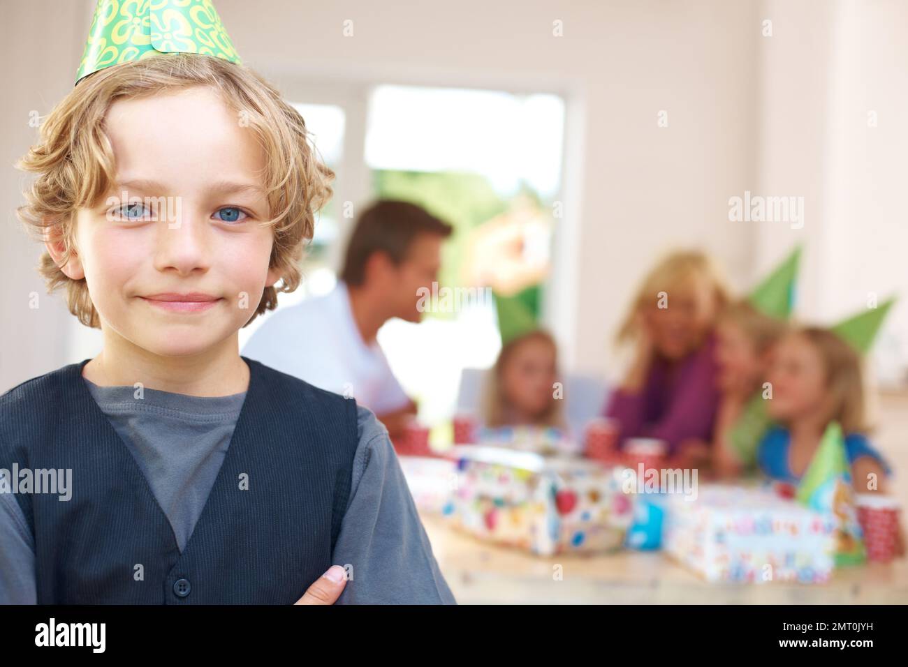Enjoying his birthday party. Cute young boy smiling while a childrens ...