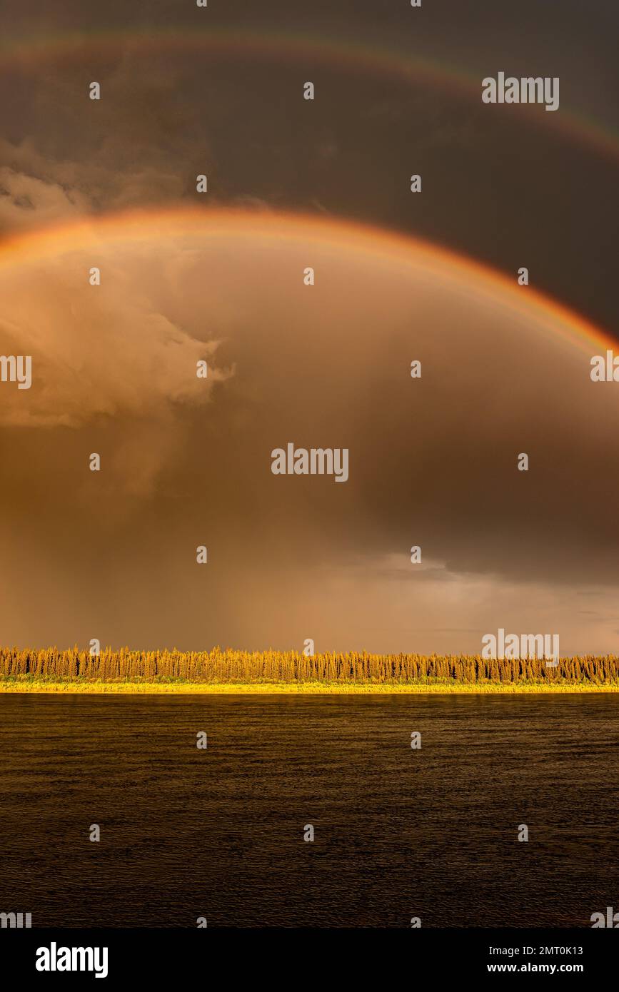 A double rainbow over the Vilyui River after rain against a dark sky ...