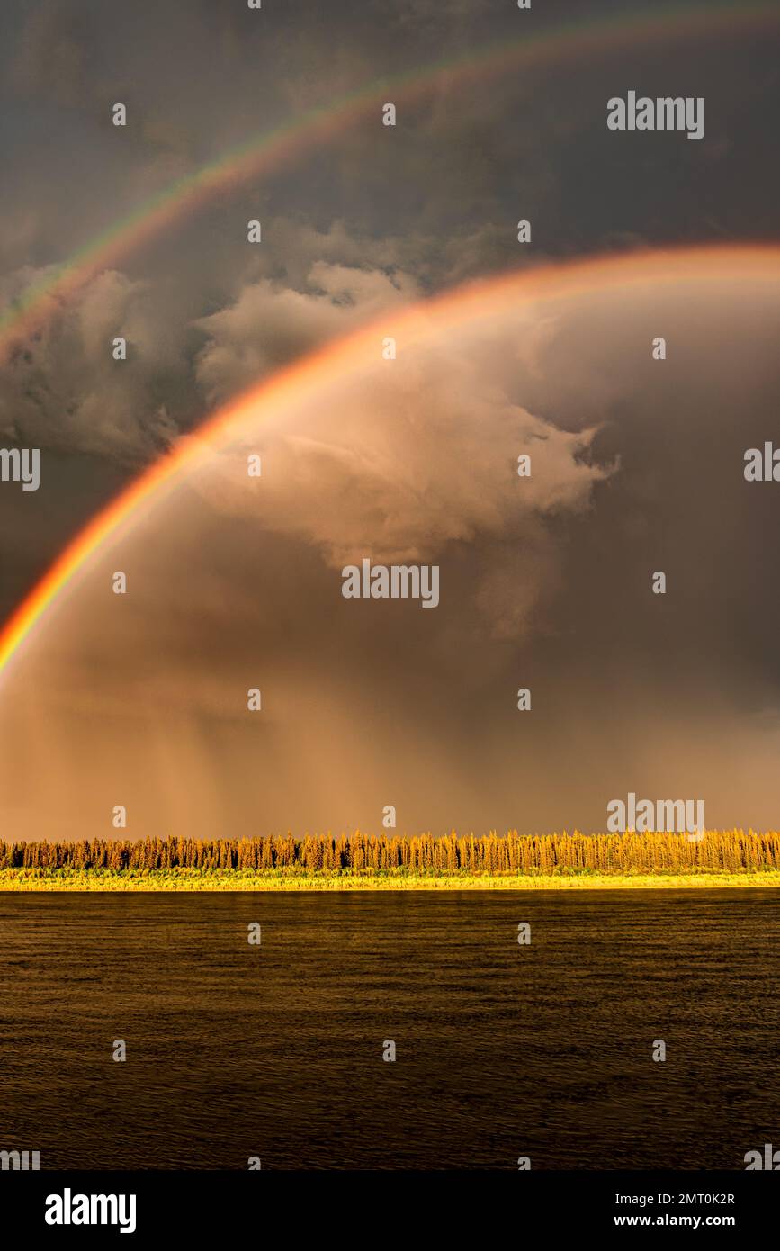 A double rainbow over the Vilyui River after rain against a dark sky ...