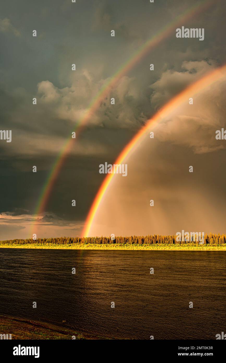 Double rainbow over the river after rain against the background of a ...