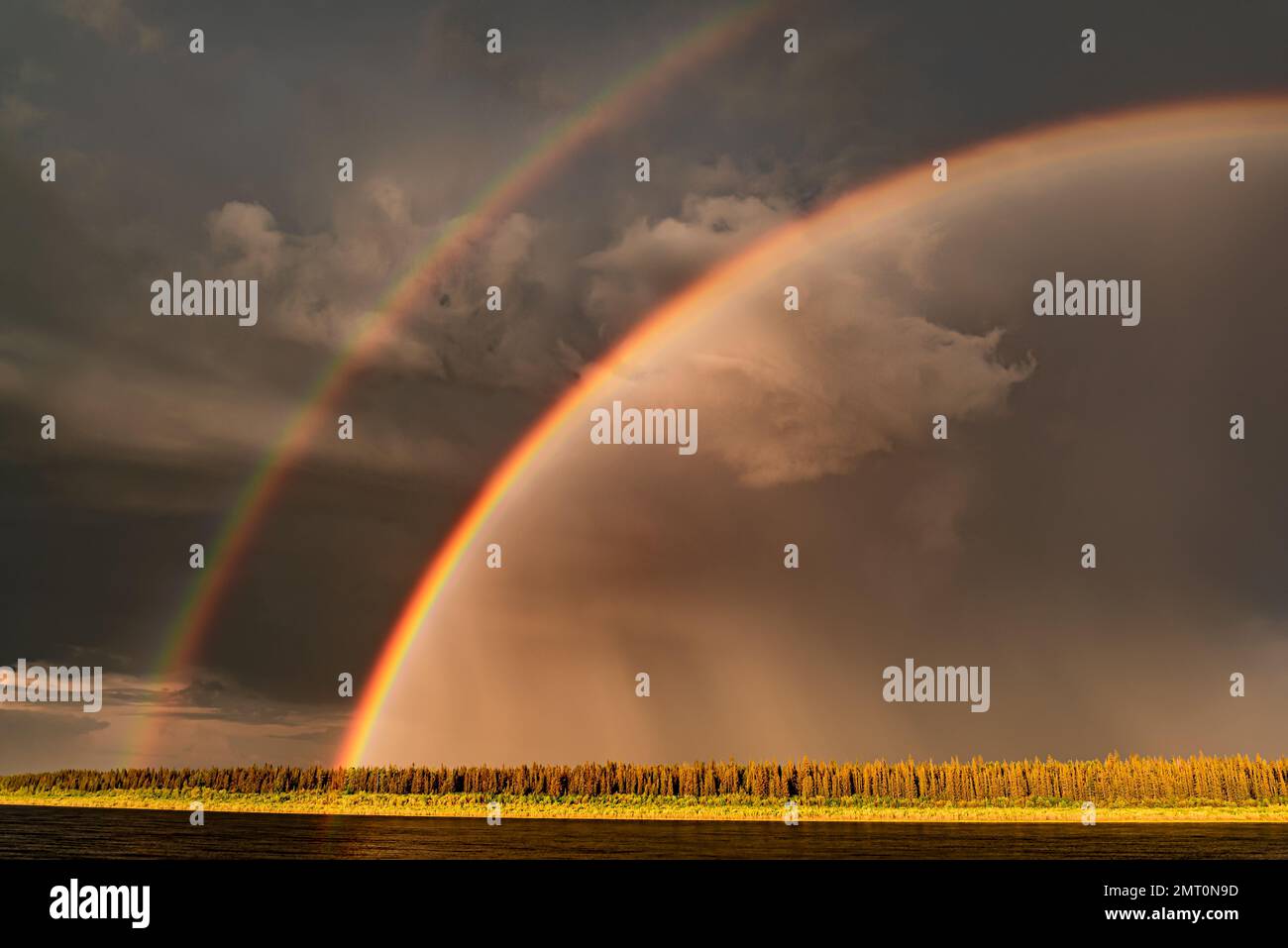 A double rainbow over the Vilyui River after rain against a dark sky ...