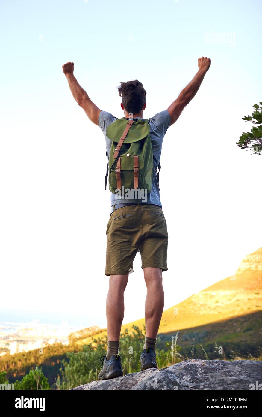 He made it. a handsome young man standing with his arms raised while ...