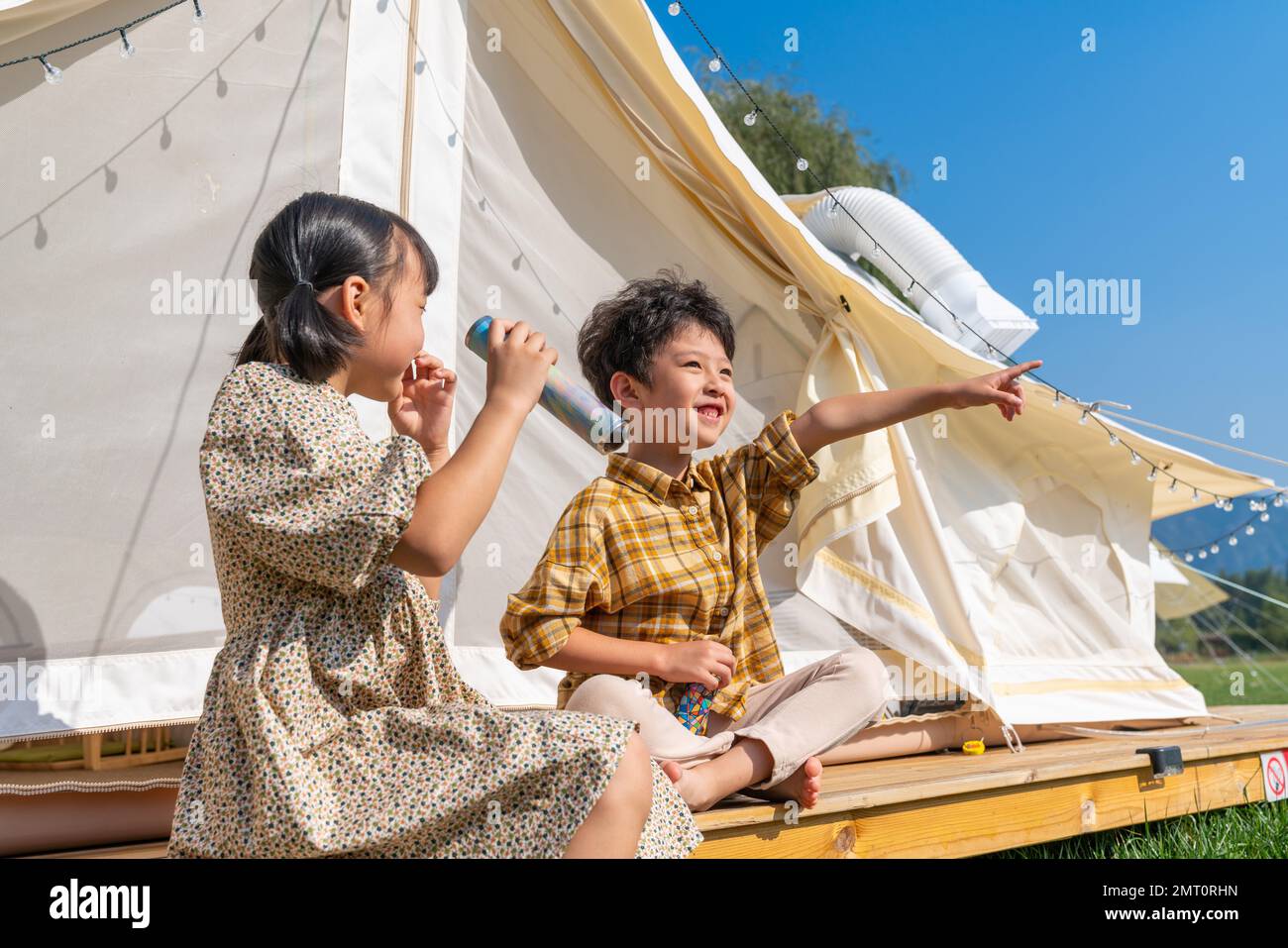 The two children playing sat outside the tent Stock Photo - Alamy