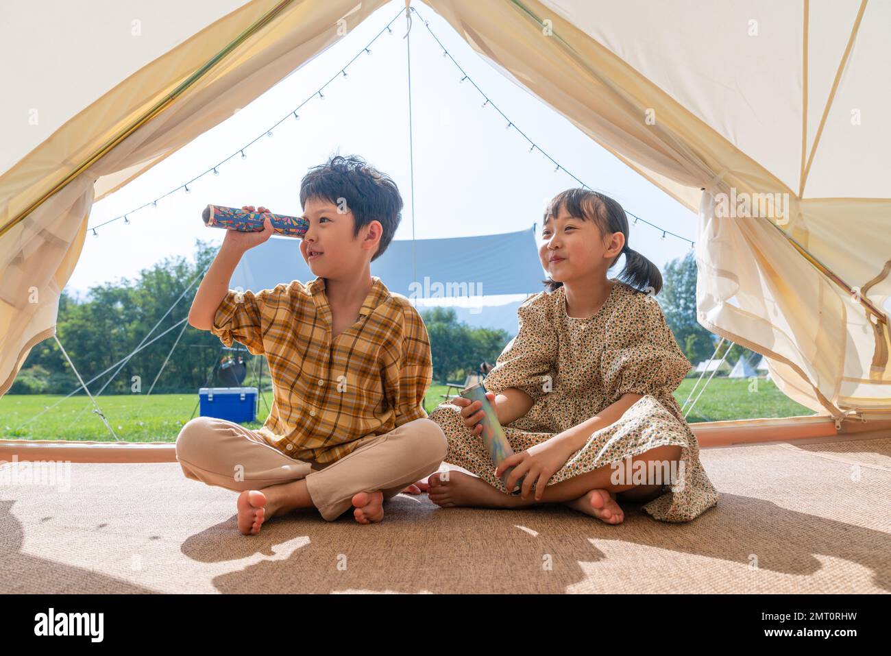 Playing two children sat in the tent Stock Photo - Alamy