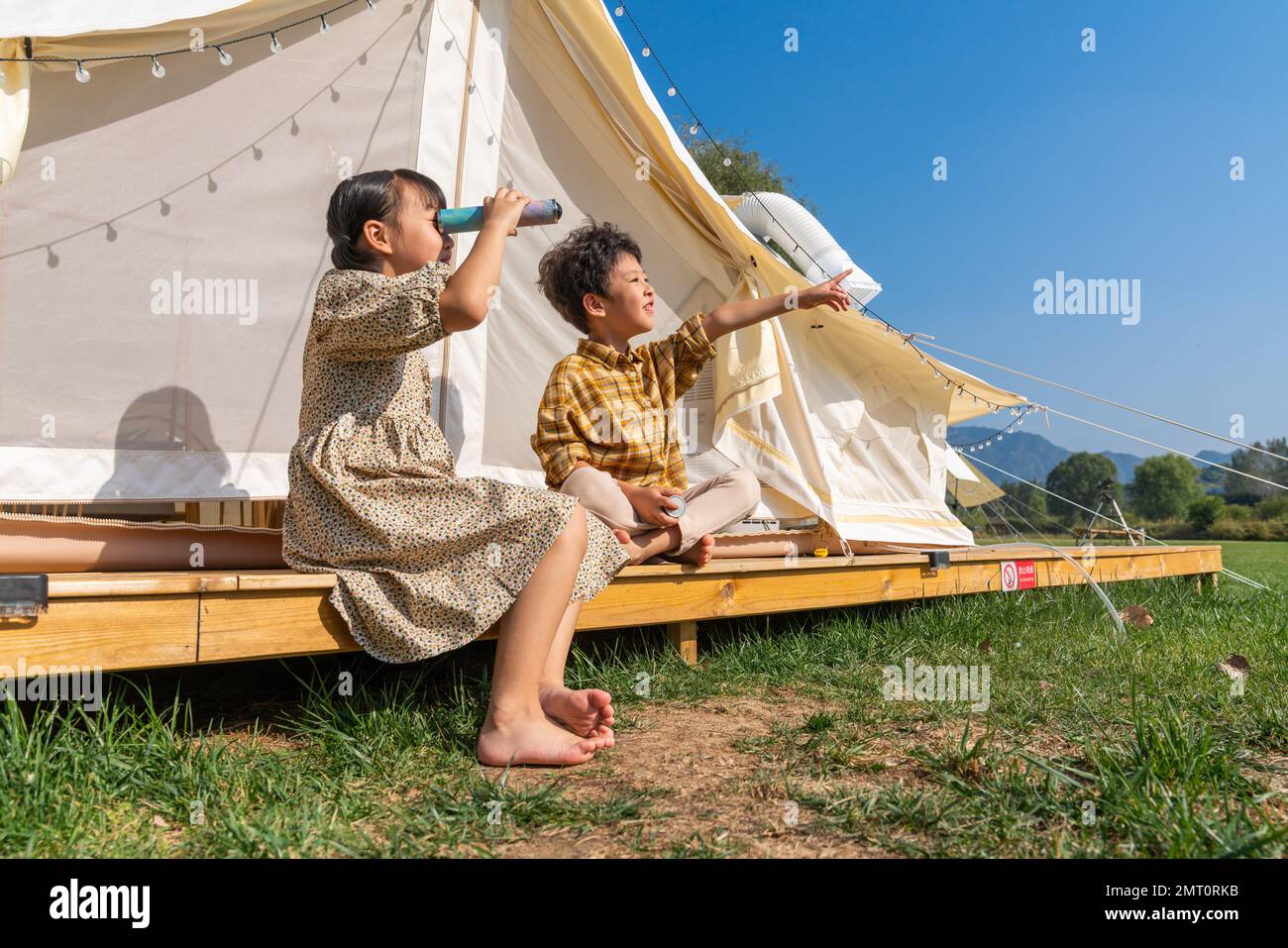 The two children playing sat outside the tent Stock Photo - Alamy