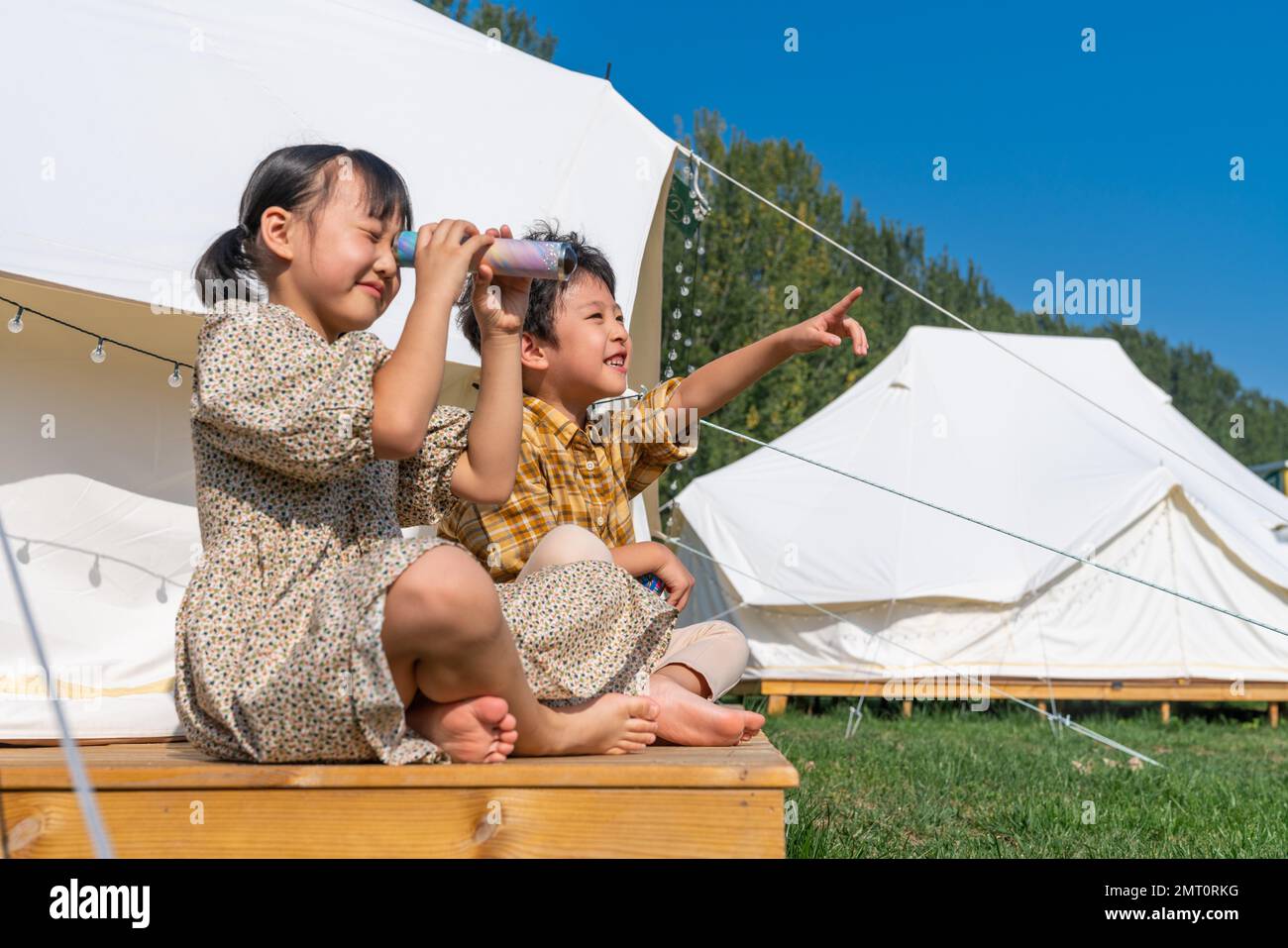 The two children playing sat outside the tent Stock Photo - Alamy