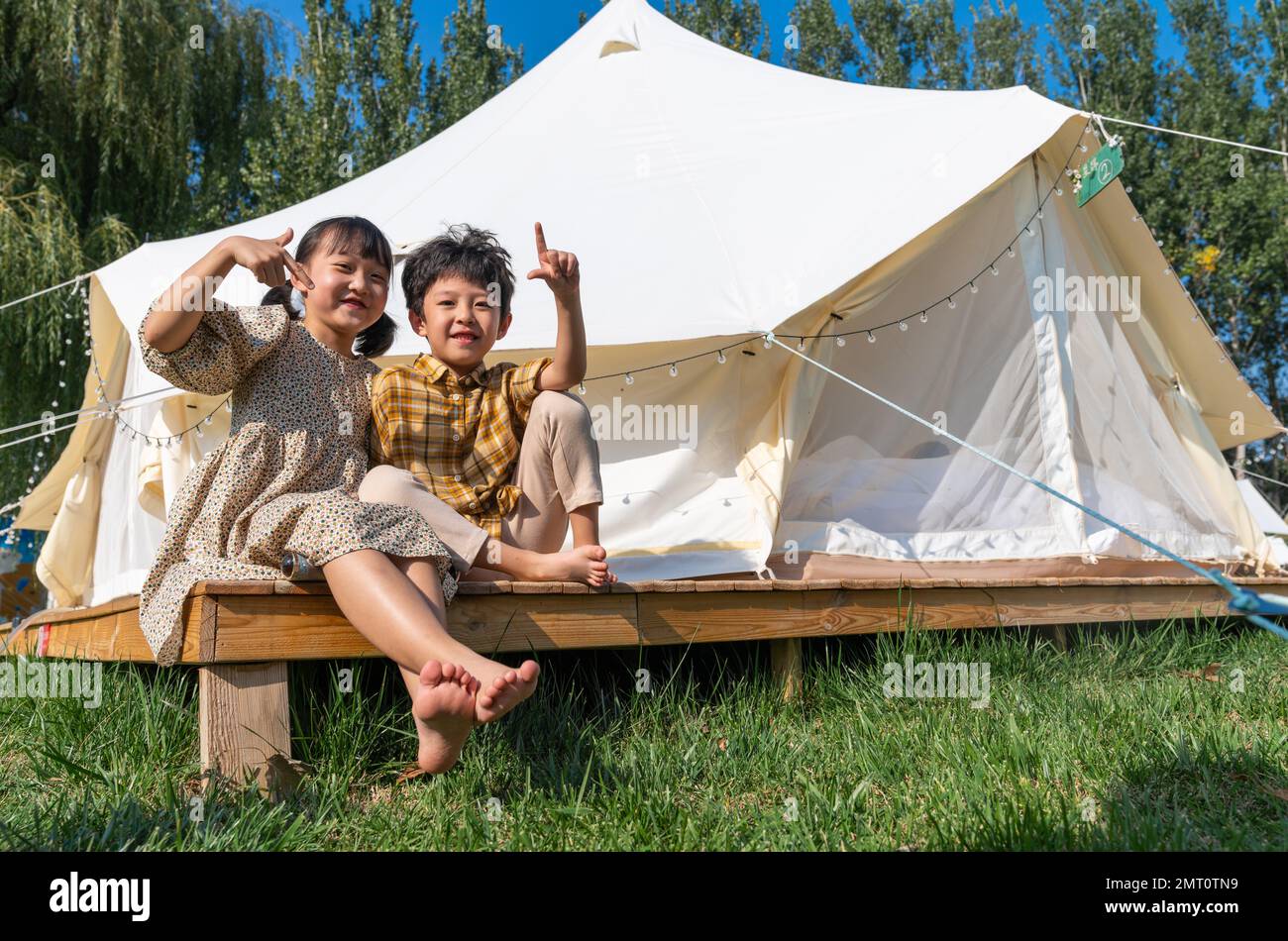 The two children playing sat outside the tent Stock Photo - Alamy