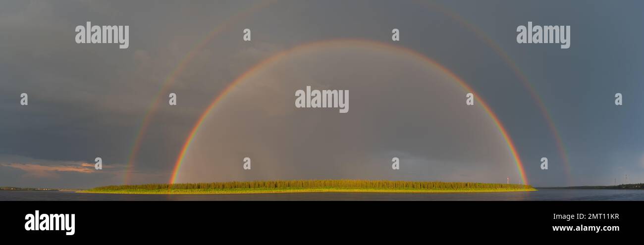 Double rainbow panorama over the Vilyui River after rain against a dark ...
