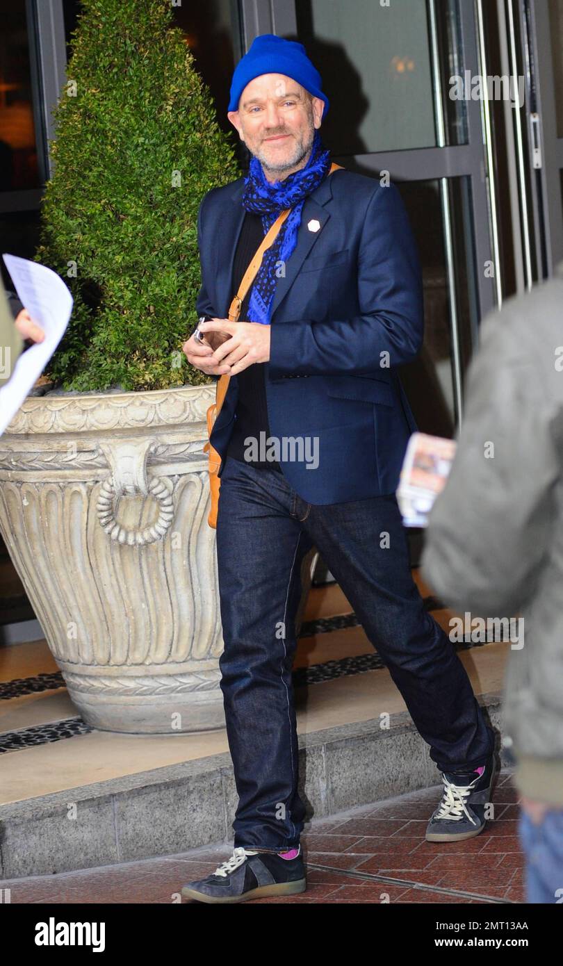 Wearing a blue cap, R.E.M. frontman Michael Stipe grins and waves to ...