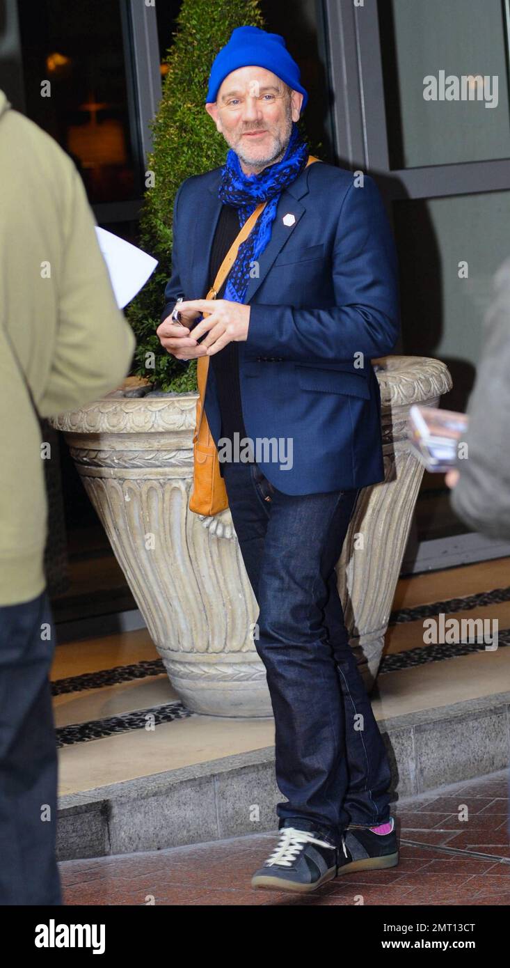 Wearing a blue cap, R.E.M. frontman Michael Stipe grins and waves to ...