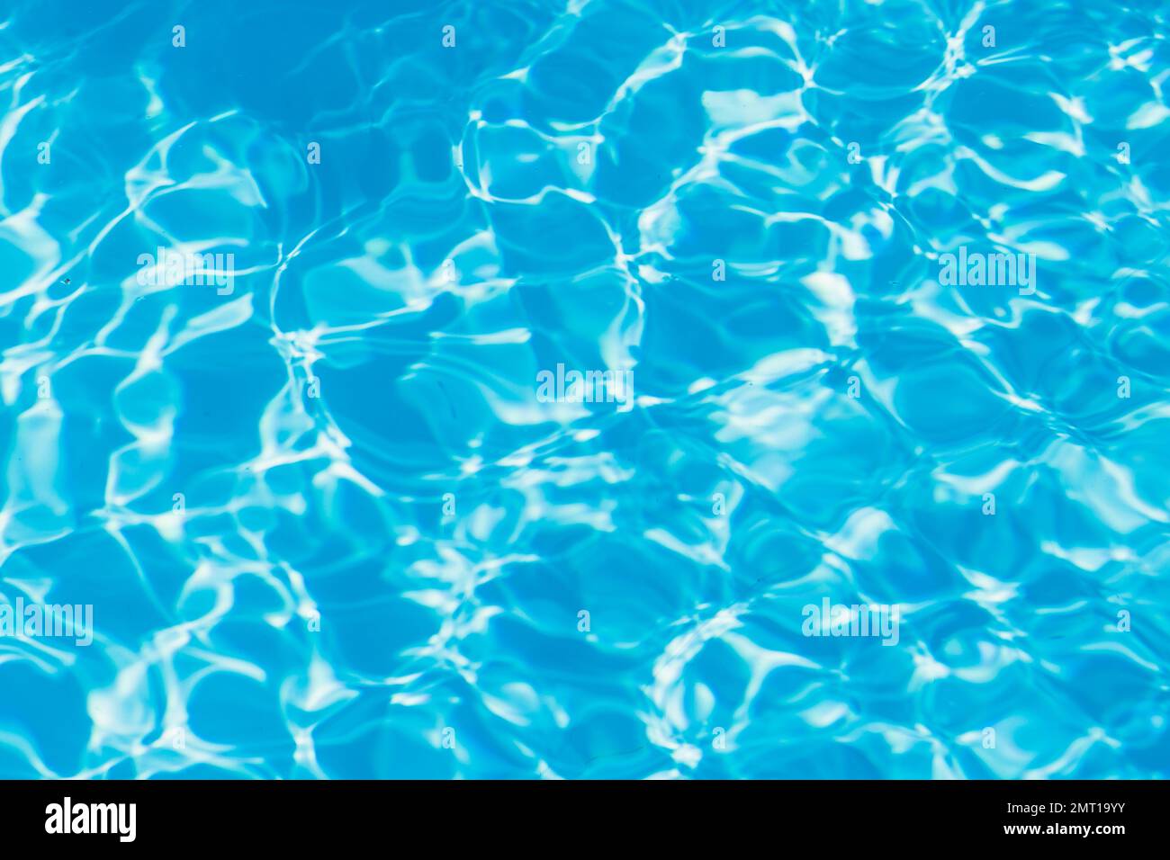 Blue pool water with sun reflections background Stock Photo - Alamy