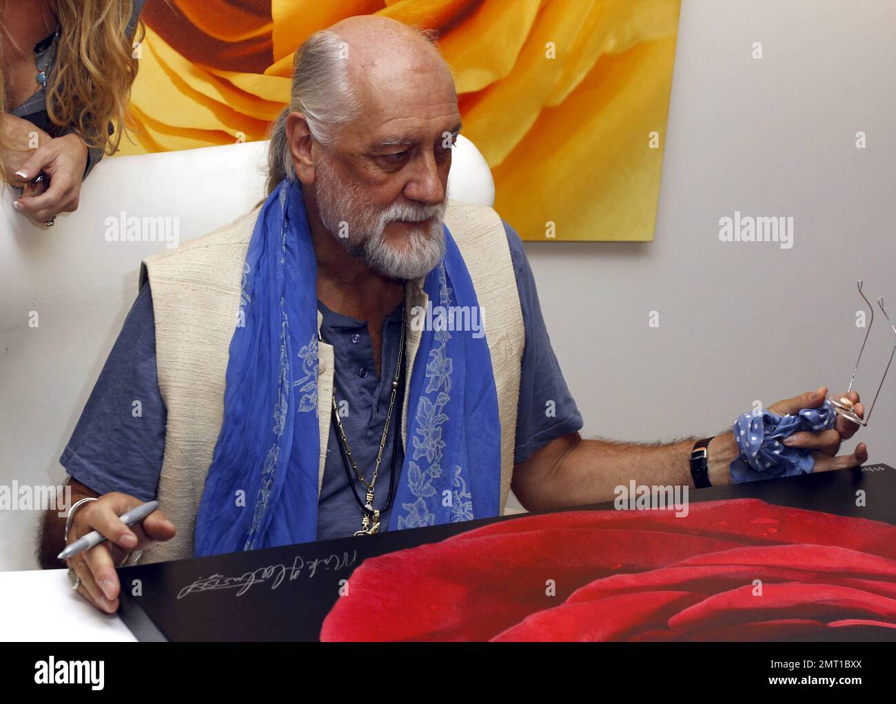 Mick Fleetwood signs copies of his work during the Rhythm of a Rose ...