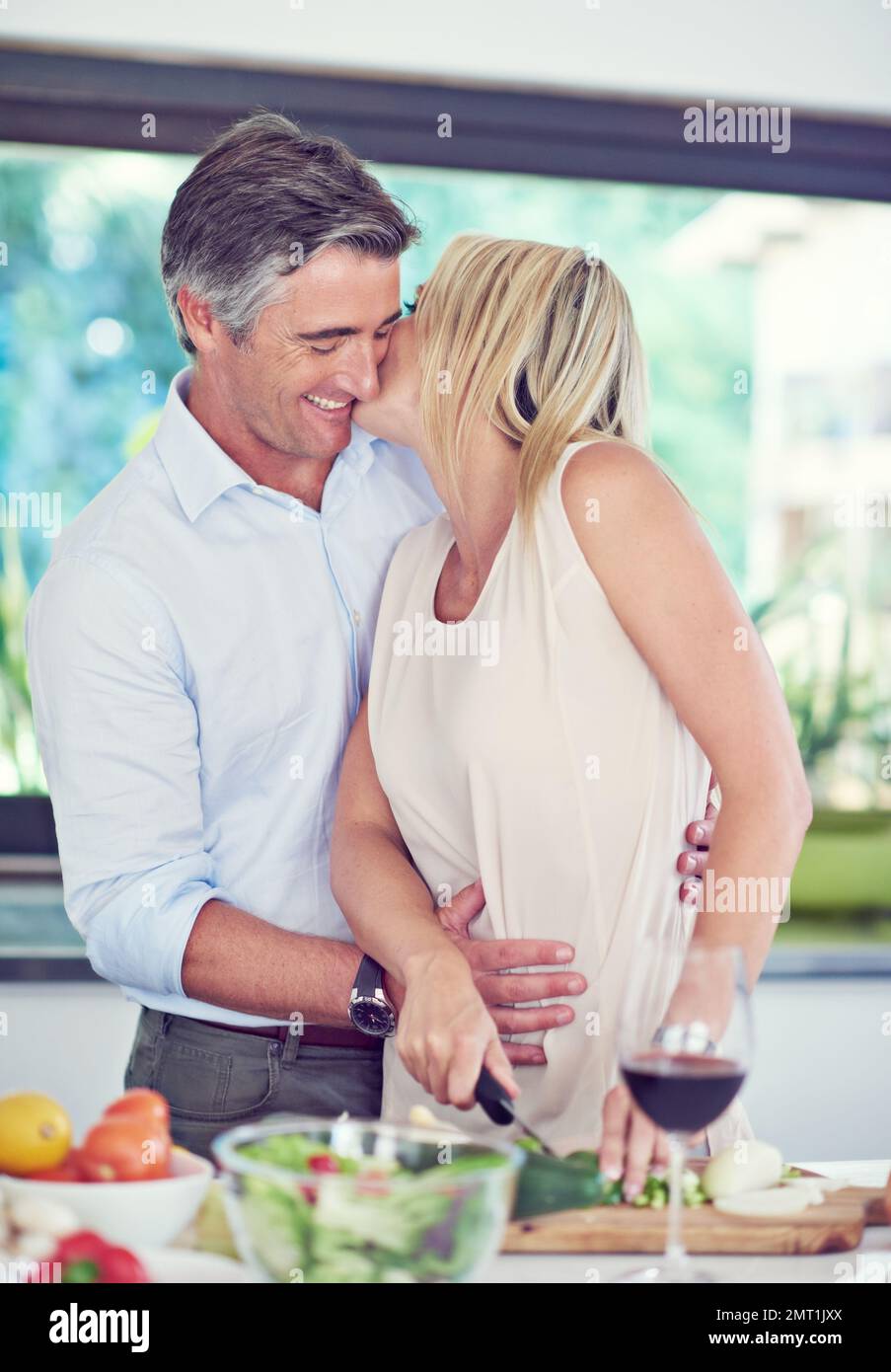 Making food and romance in the kitchen. an affectionate couple cooking ...