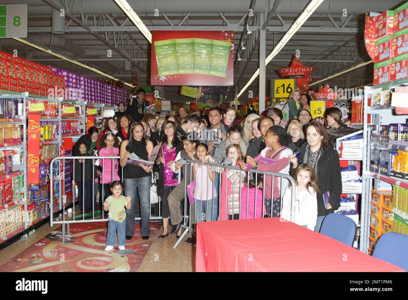 Dozens of fans wait behind guardrails as pop singer Miley Cyrus poses ...