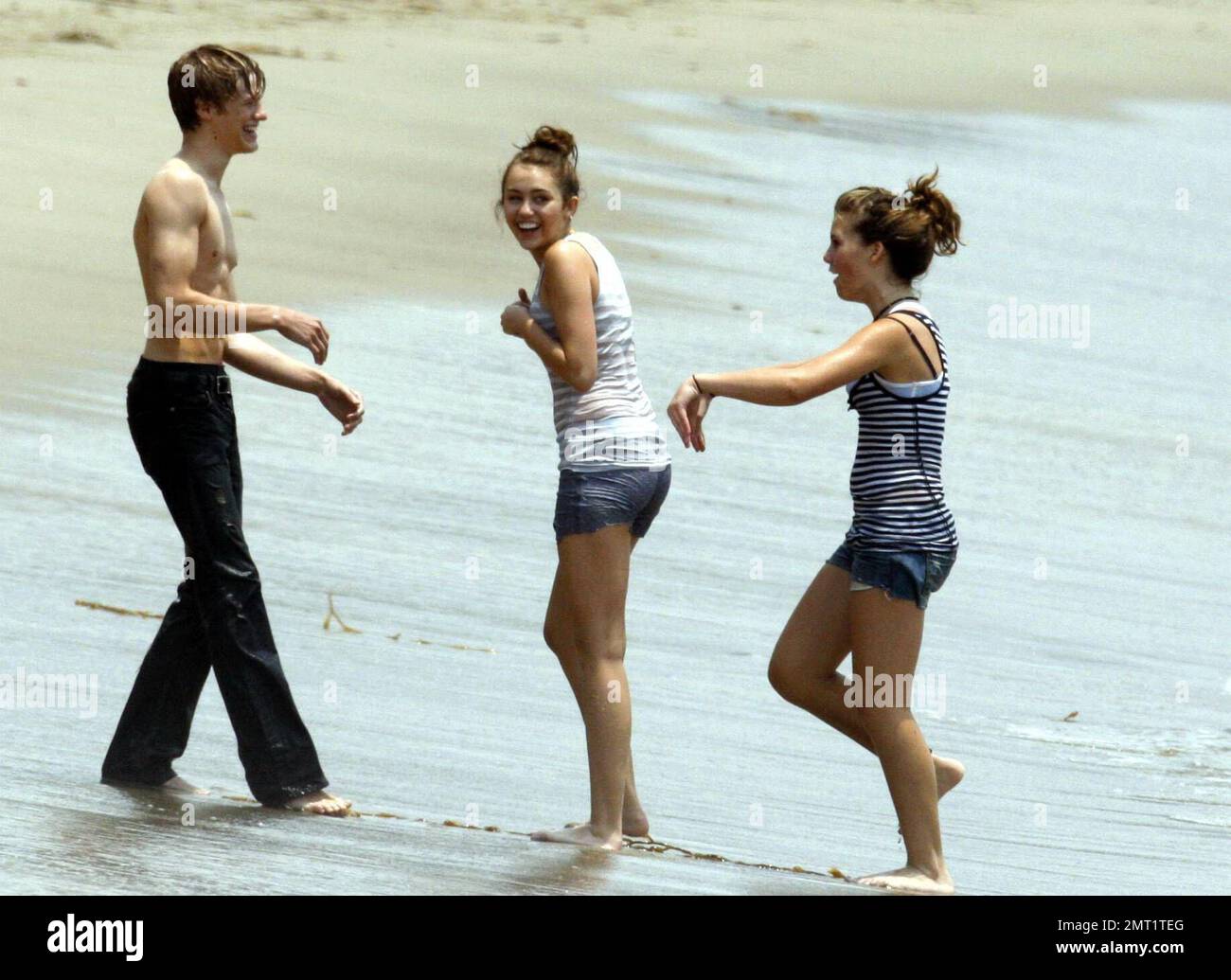 Miley Cyrus frolics in the surf with friends/castmates while filming ...