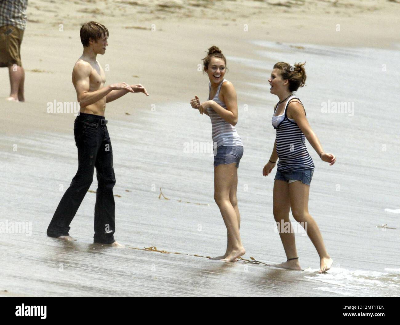 Miley Cyrus frolics in the surf with friends/castmates while filming ...