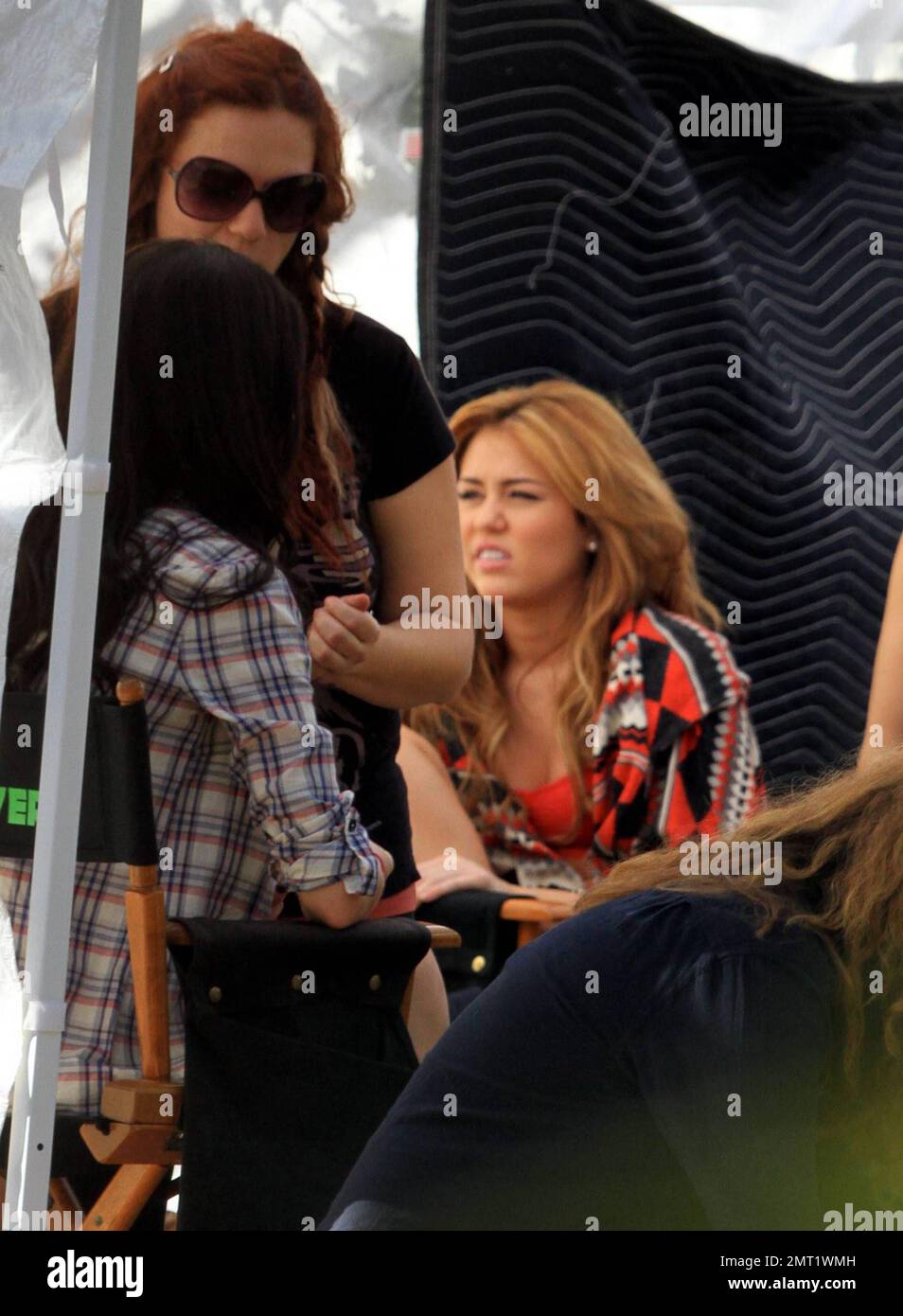 Miley Cyrus looks pensive as she takes a break on the set of her new ...