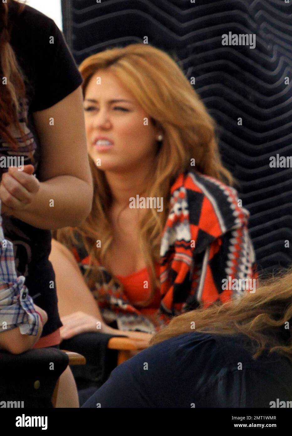 Miley Cyrus looks pensive as she takes a break on the set of her new ...
