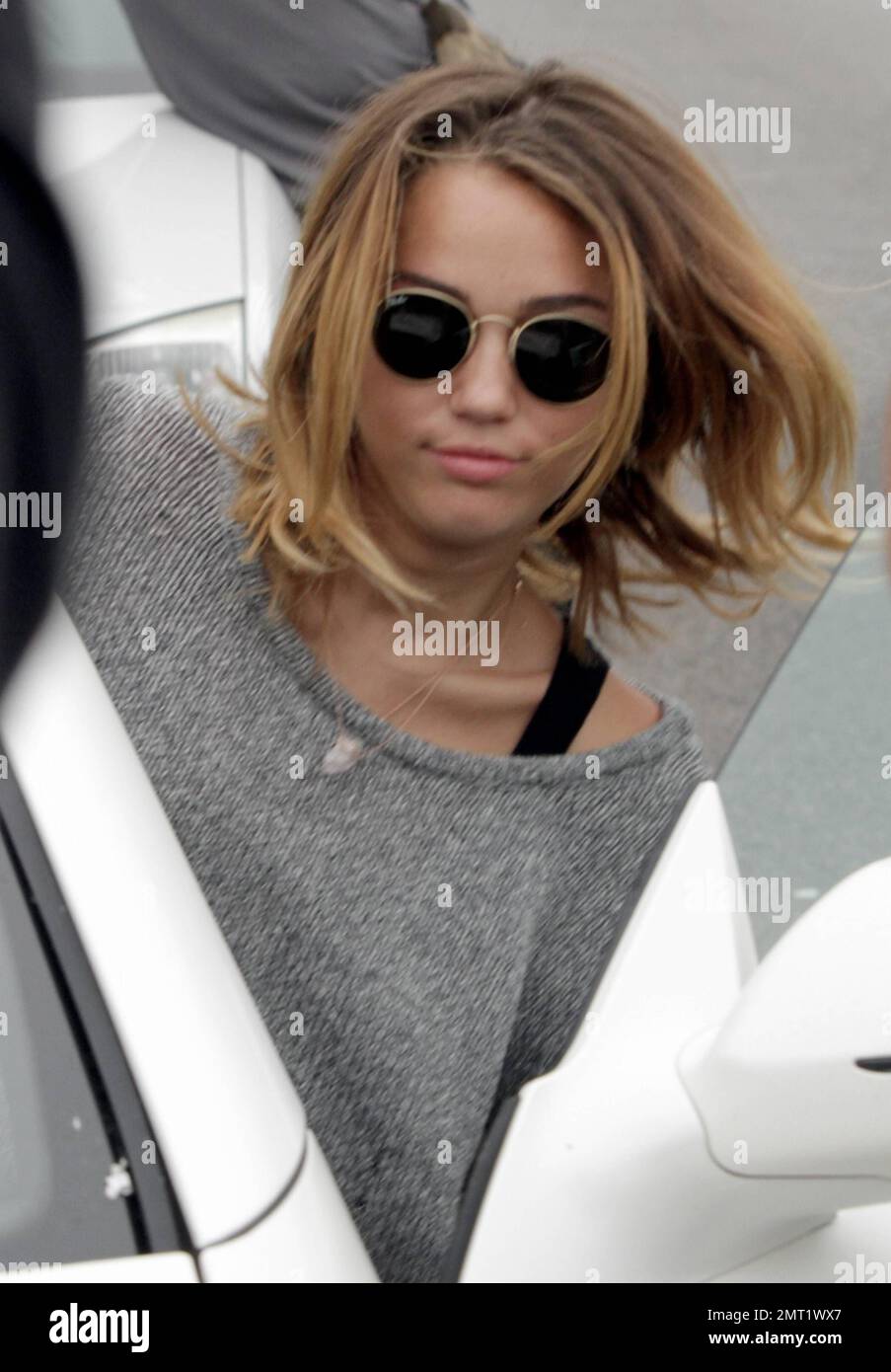 Wearing a grey sweater over her all-black workout outfit, Miley Cyrus ...
