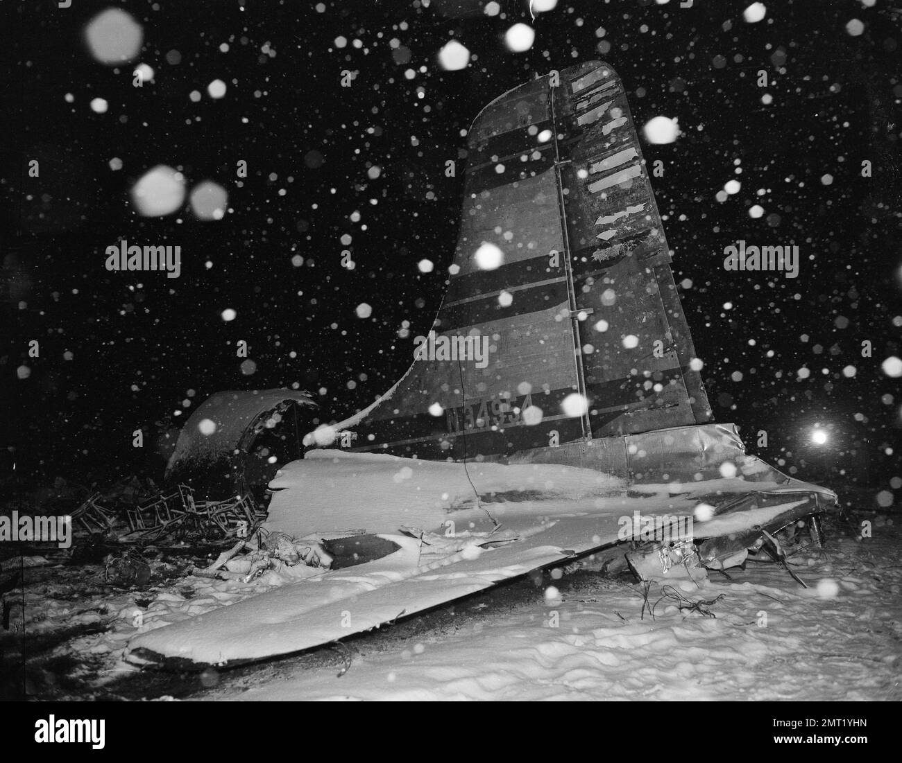 Debris and wreckage litter the ground around the tail section of ...