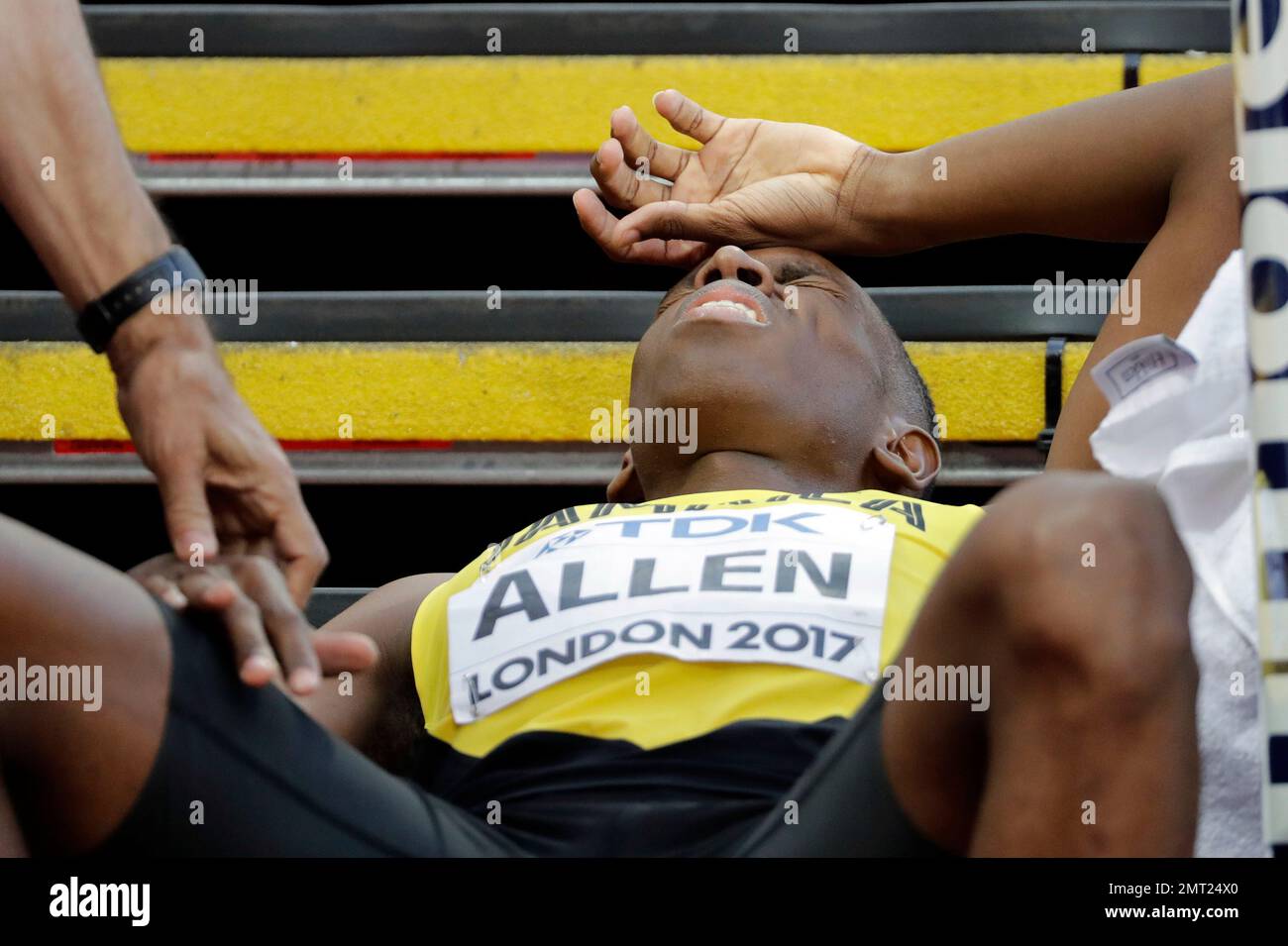 Jamaica's Nathon Allen grimaces as he rests on the stairs to the mixed ...
