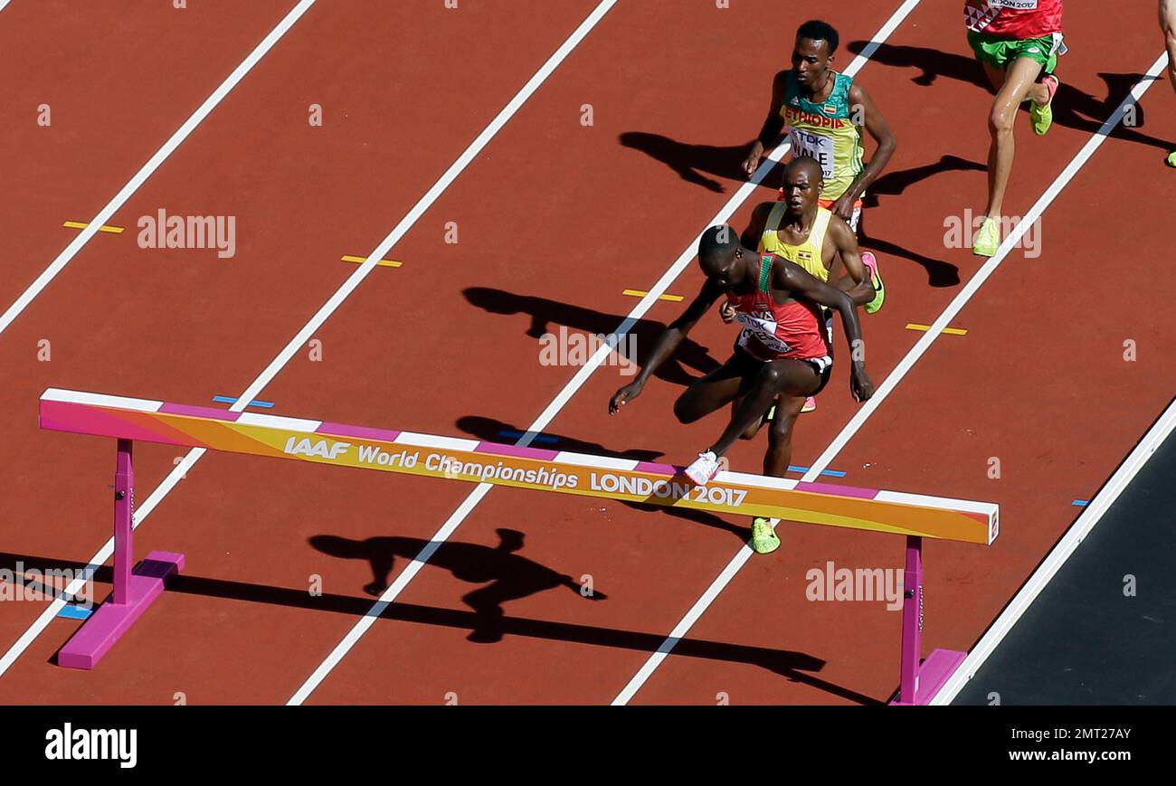 Kenya's Jairus Kipchoge Birech, front, clears an obstacle in a men's ...