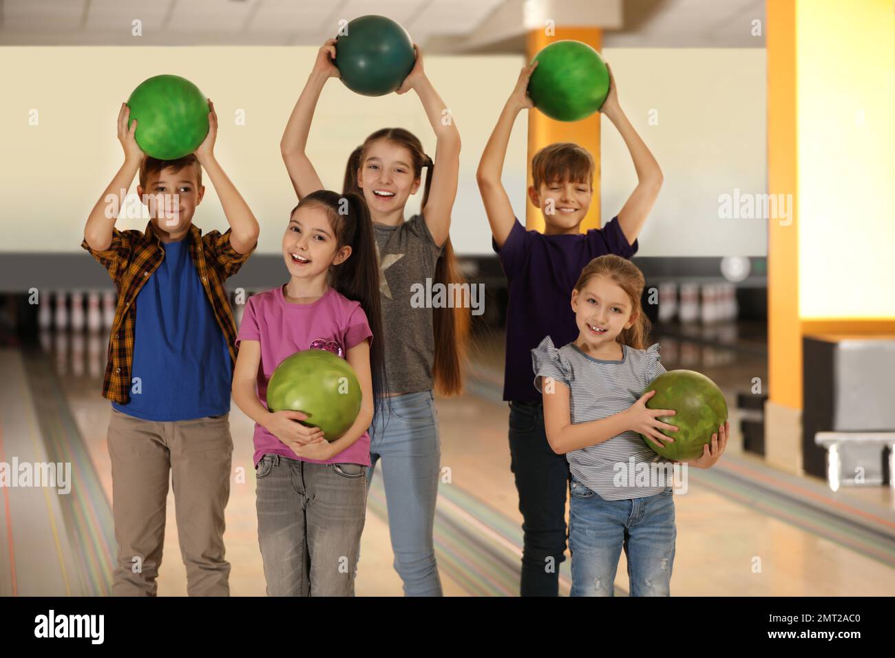 Happy children with balls in bowling club Stock Photo - Alamy