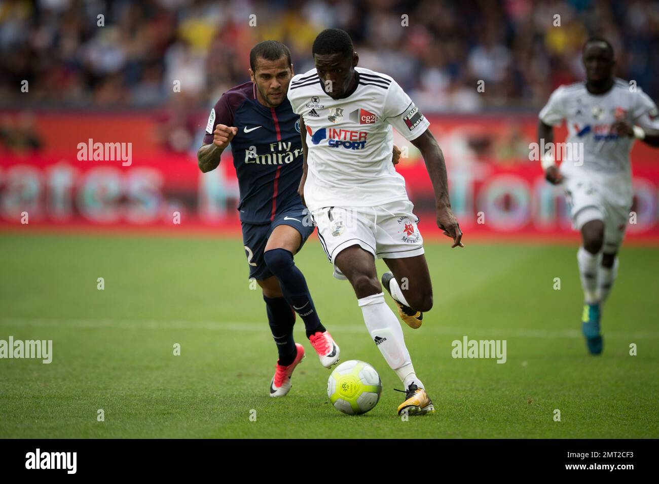 PSG's Dani Alves, left, challenges for the ball with Amien's Harrison ...