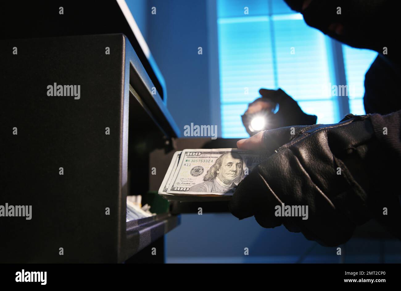 Thief taking money out of steel safe indoors at night, closeup Stock ...