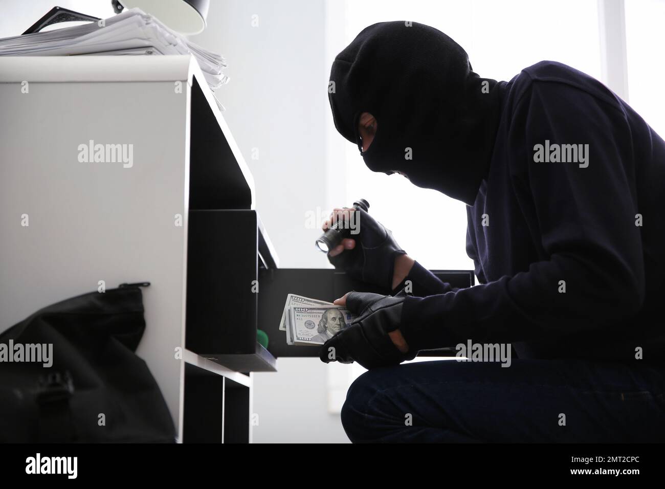Thief taking money out of steel safe indoors Stock Photo - Alamy