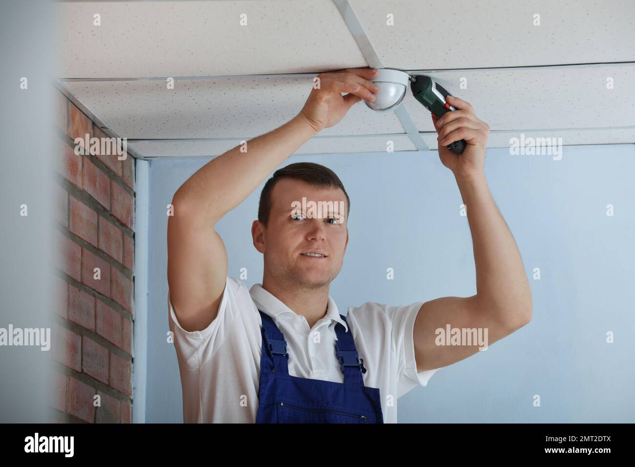 Technician installing CCTV camera on ceiling indoors Stock Photo - Alamy