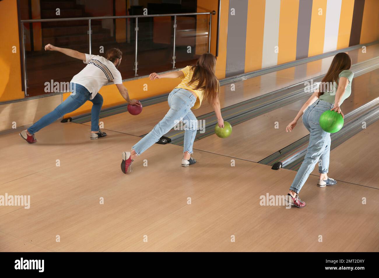 Group of friends throwing balls in bowling club Stock Photo - Alamy