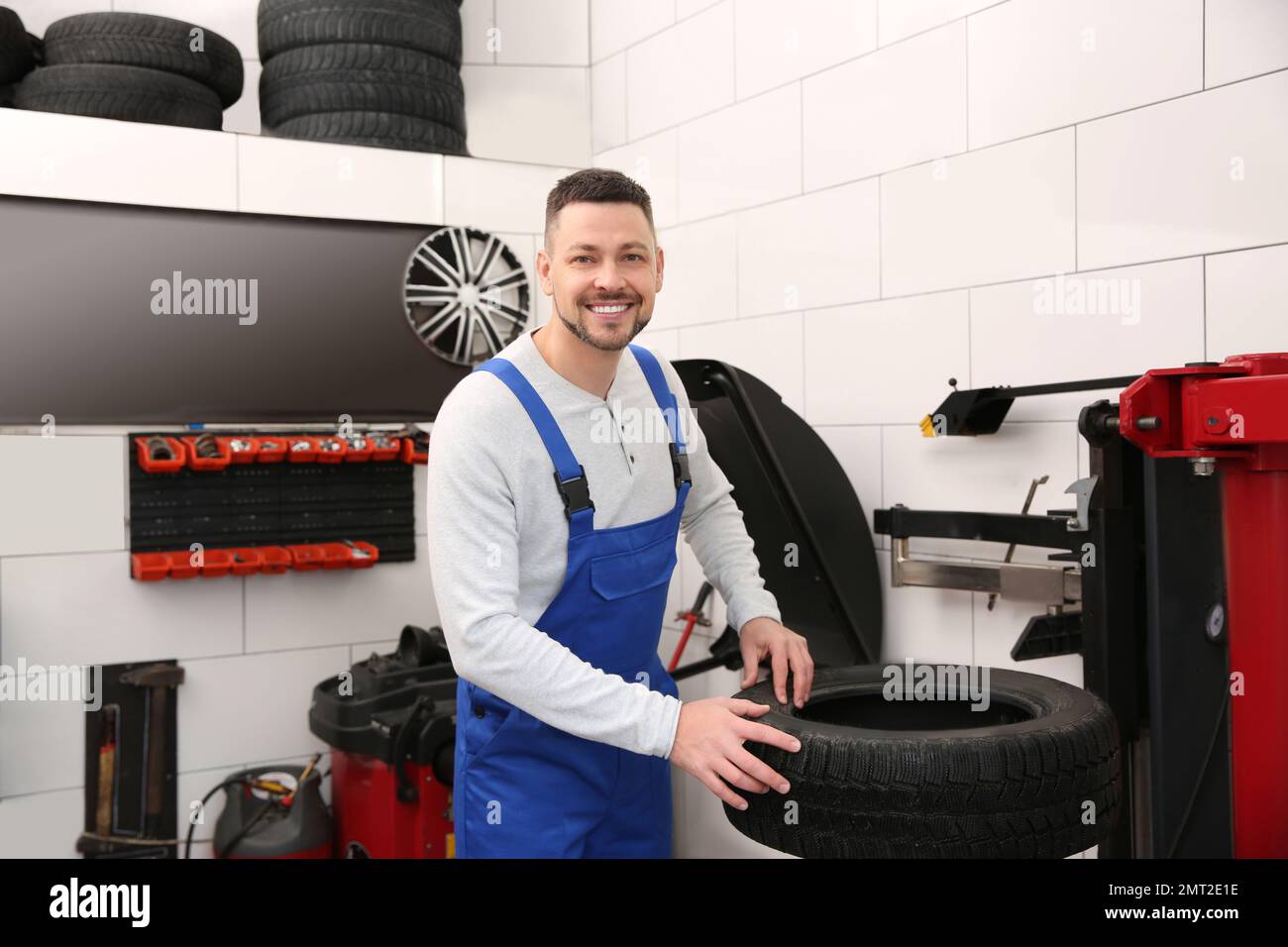 Mechanic working with tire fitting machine at car service Stock Photo ...