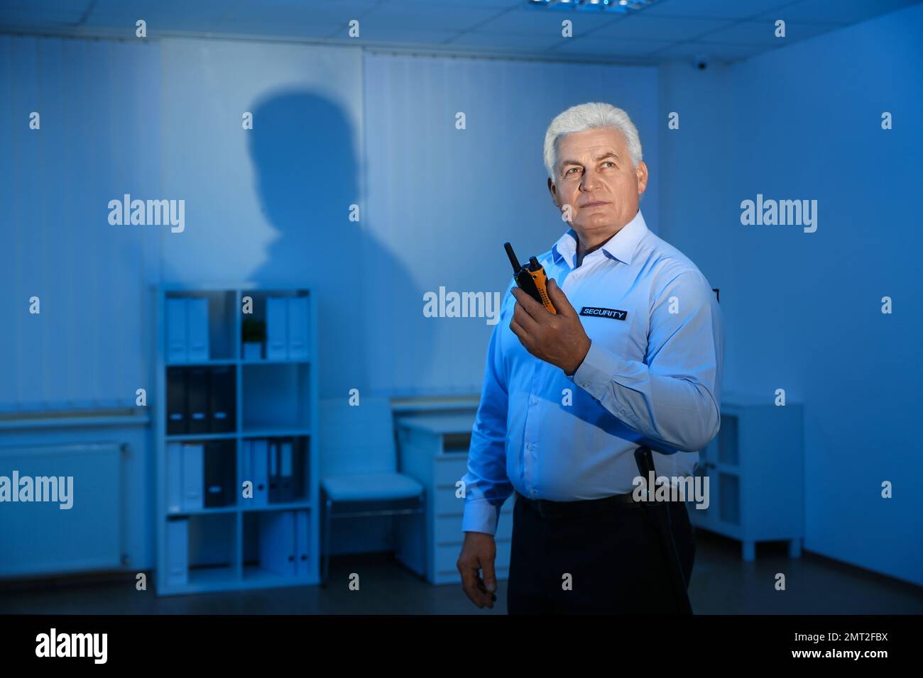 Professional security guard with portable radio set in dark room Stock ...