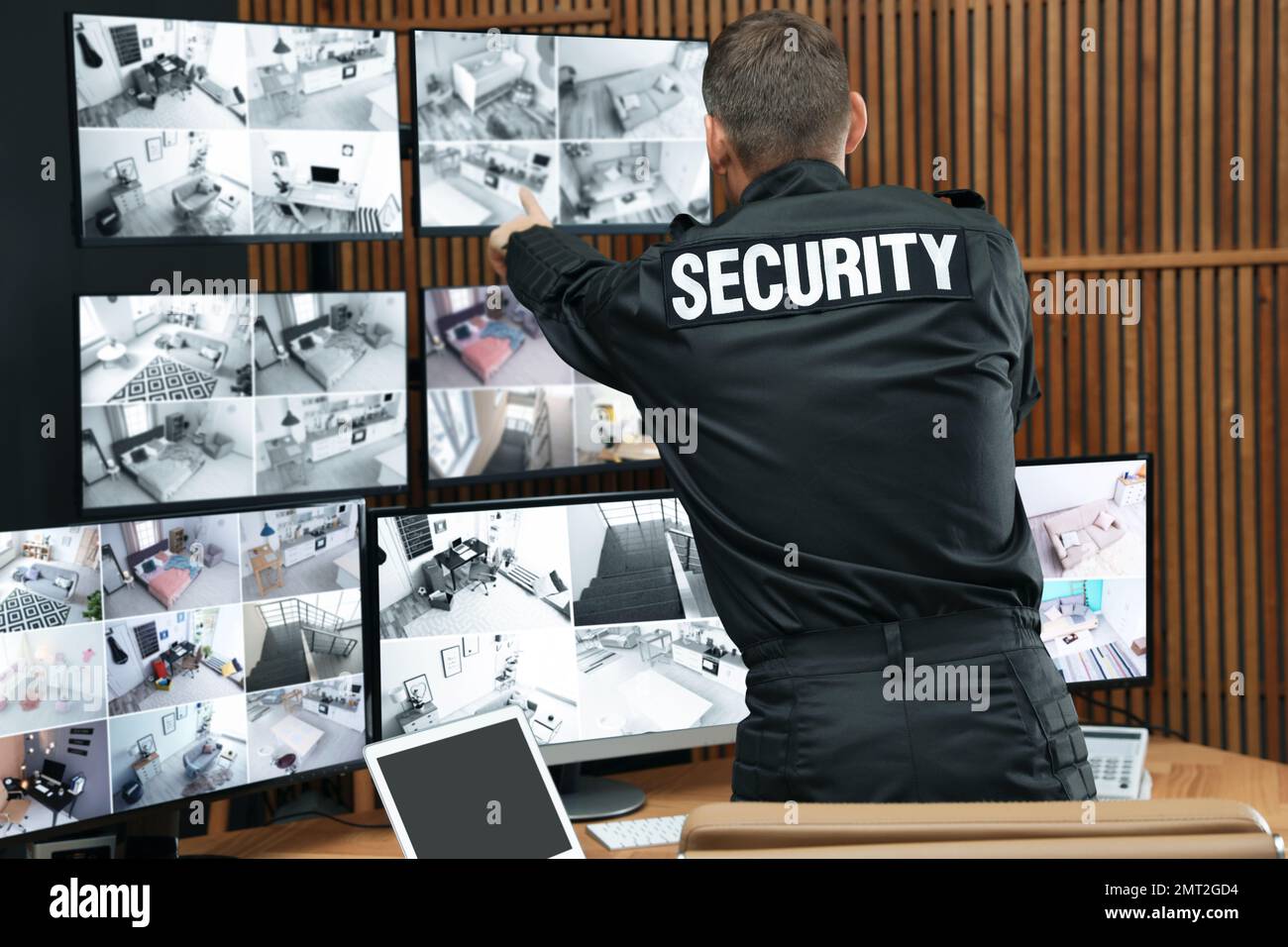 Security guard with portable transmitter monitoring modern CCTV cameras ...