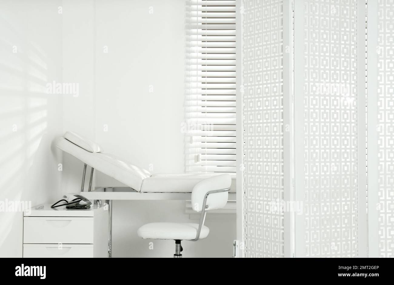 Examination room with modern couch and folding screen in clinic Stock ...