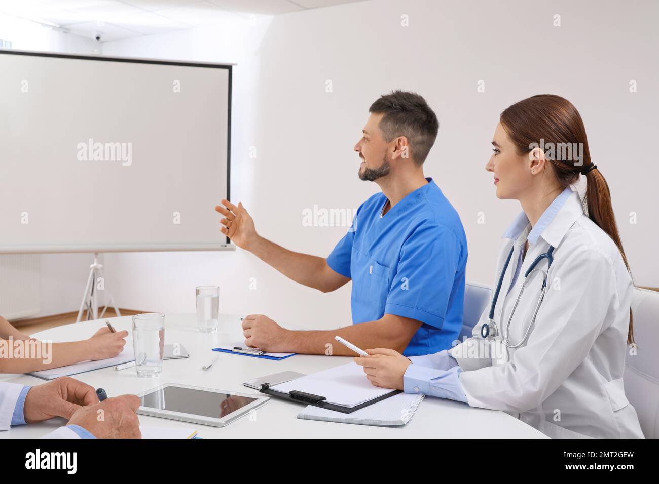 Team of doctors looking at projection screen indoors Stock Photo - Alamy