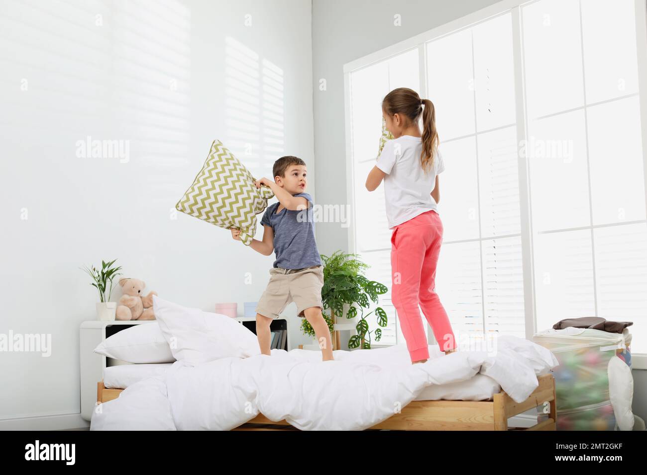 Happy children having pillow fight in bedroom Stock Photo - Alamy
