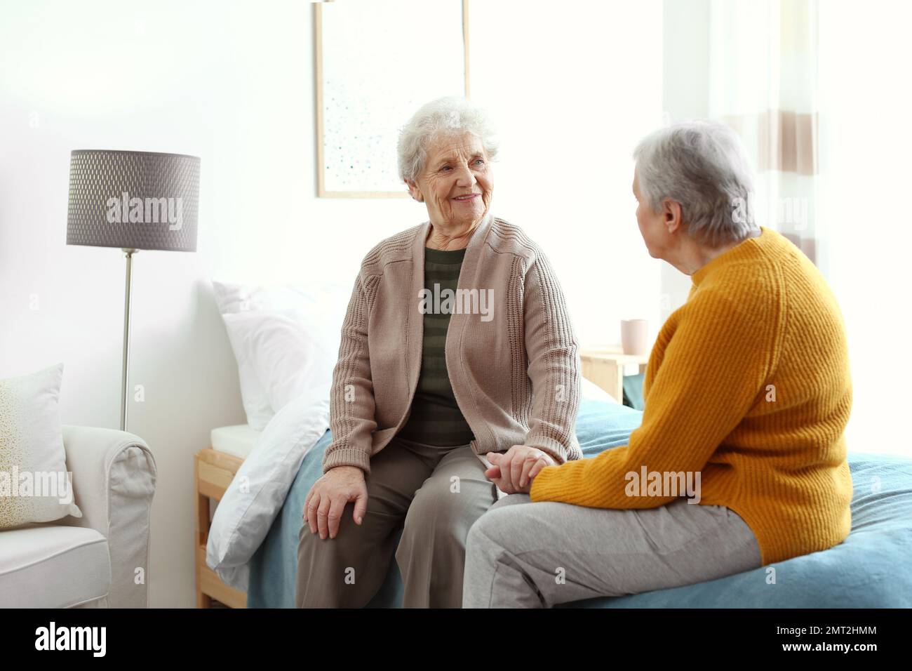 Elderly women spending time together in bedroom. Senior people care ...