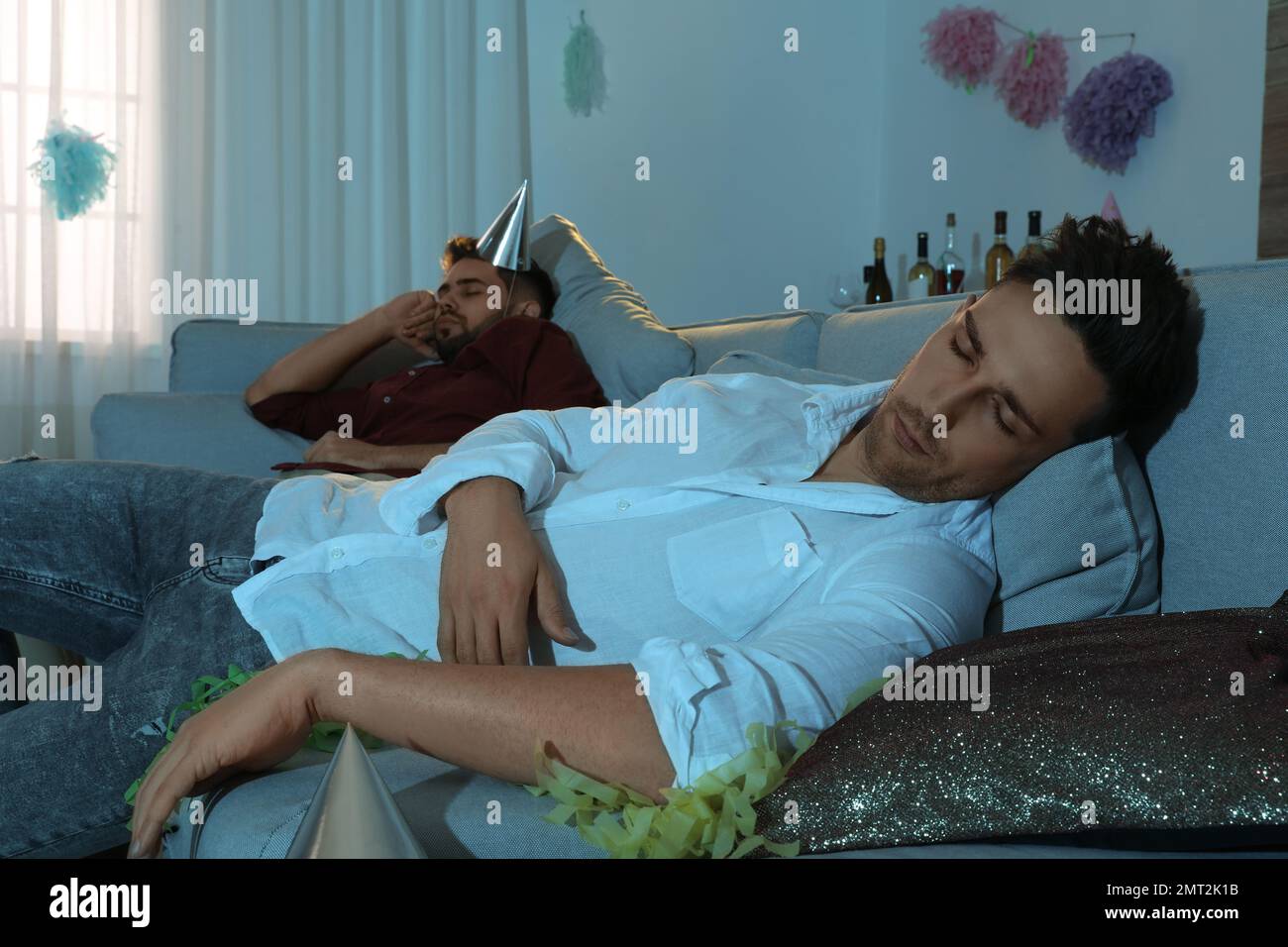 Drunk men sleeping on sofa in room after party Stock Photo - Alamy