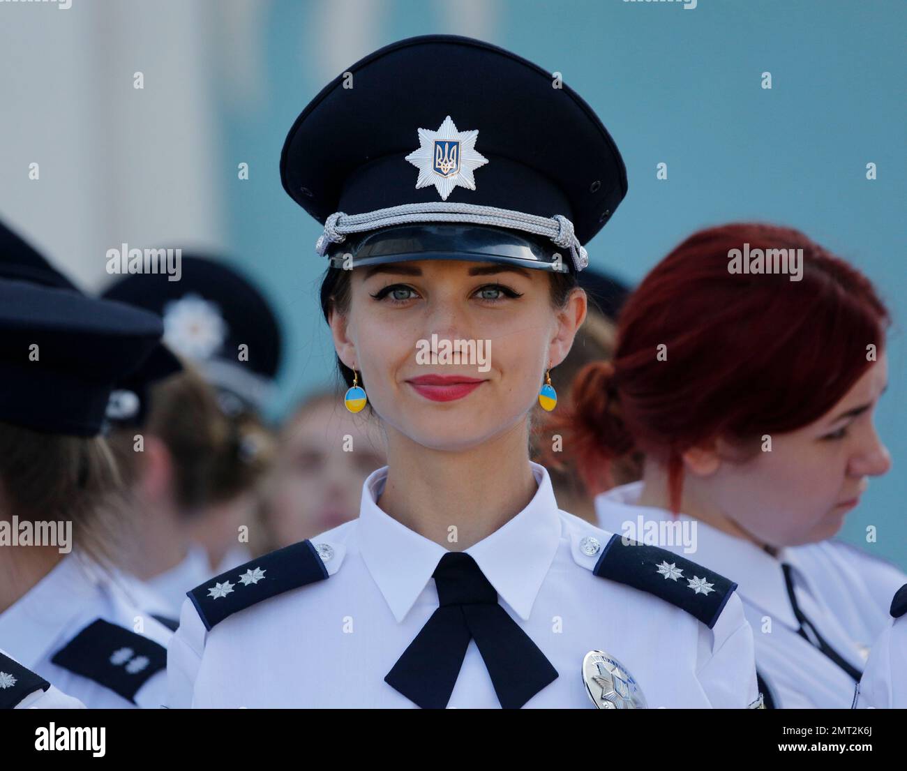 A women police unit officer, ear-rings in Ukraine's national colours ...